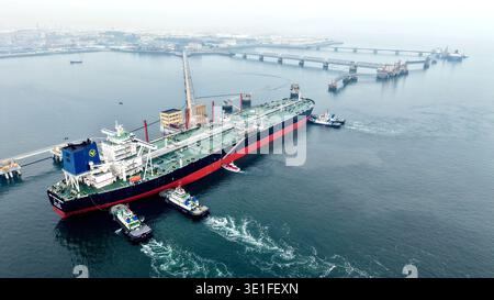 An oil tanker carrying imported crude oil docks at a berth in Qingdao ...
