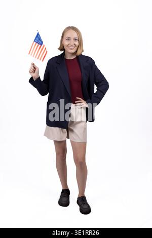 Young woman with USA flag pointing at viewer on blue background ...