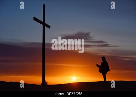 Christian prayer group gathered around an open Bible and wooden cross ...