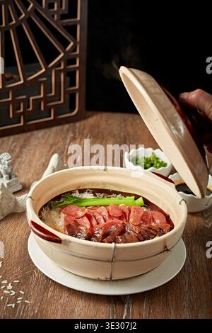 Traditional Cantonese claypot rice with cured pork belly bacon on ...