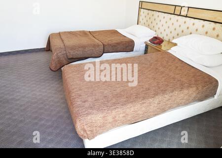 Simple standard hotel room interior featuring two single twin beds ...