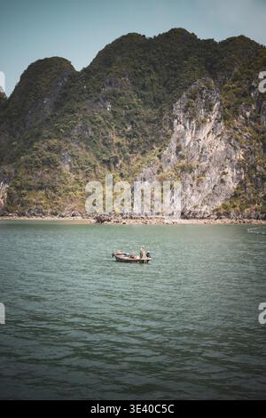 Local fishermen in small wooden boat on foreground with offshore supply ...
