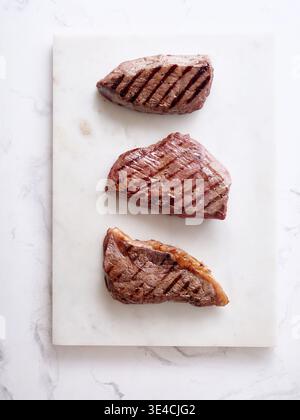 Grilled steak with charred grill marks red peppercorns served on white ...