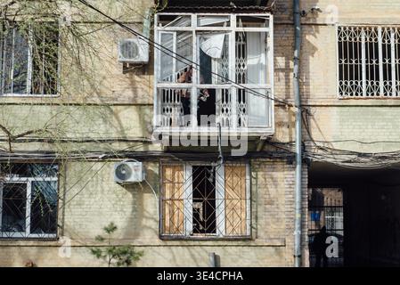 A resident stands on a balcony during an apartment block fire in ...