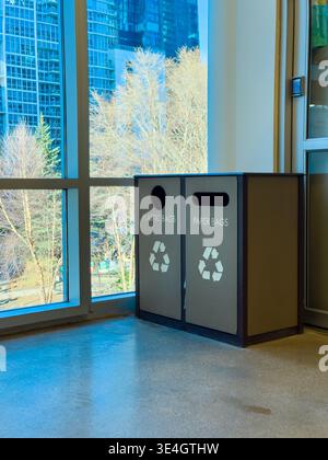 Two waste collection bins, one grey and one green, stand in a natural ...