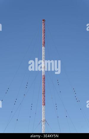 A tall radio transmission mast rises above the barren volcanic ...