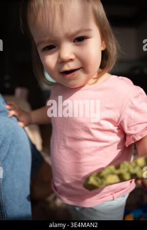 Curious Toddler Reaching for a Toy on the Kitchen Floor Stock Photo - Alamy