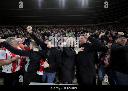 Arsenal fans celebrate on the side of street and on a bus shelter as ...