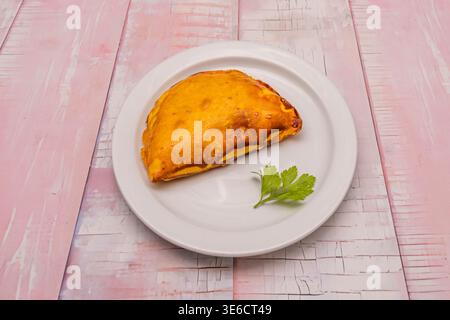A platter of ham and cheese empanadas, the cheese melted and oozing out ...