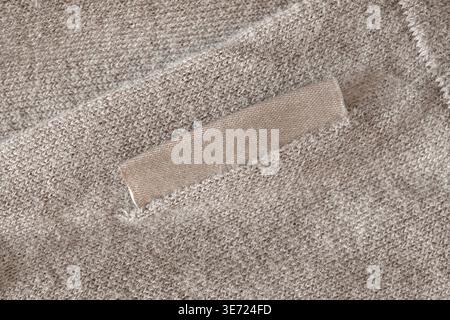 Blank clothes tag on beige wool background closeup Stock Photo - Alamy
