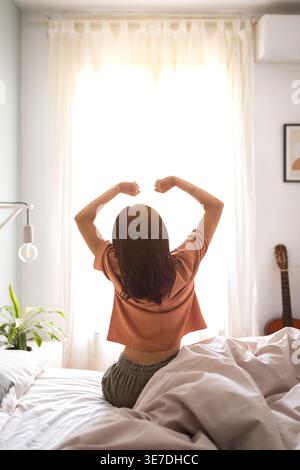 Asian women stretch arm wake up morning routine living room home bright ...