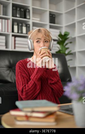 Teen boy with headphones using laptop on white background Stock Photo ...