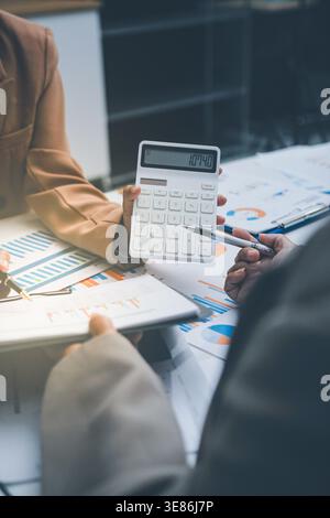 Man analyzing financial charts and tax documents at home desk for ...