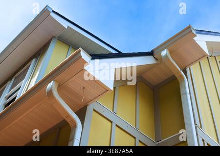 Yellow Hardie siding new house rooflines, edges gutter details Stock ...