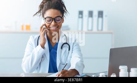 A medical professional talks on a phone while holding a clipboard Stock ...