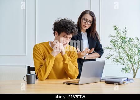 Female mentor teacher and male university student together inside the ...