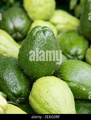 Vibrant green mint leaves piled on rustic wooden board. Red cherry ...