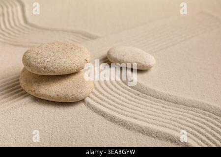 Composition with spa stones and lines on sand as background, closeup ...