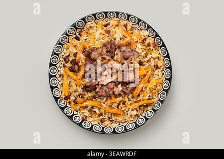 A hearty portion of pilaf with meat and vegetables served in a textured ...