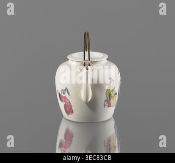 A yellow teapot sits on a blue and green wooden surface. A pile of ...