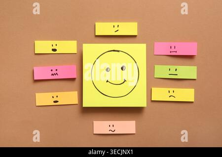 Sticky papers with drawings of different emotion faces on brown ...