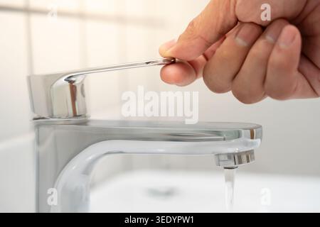 Save water. Man keeps turning off the running water in the bathroom to ...
