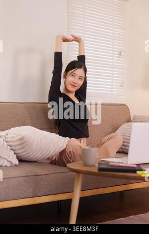 young Asian women stretch arm relax morning waking up sitting on living ...