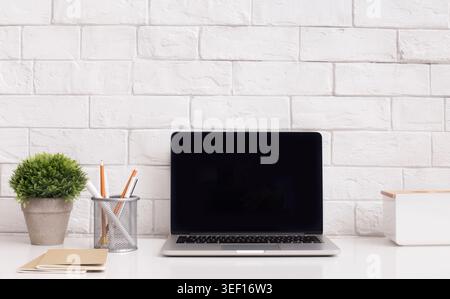 Green plant with laptop and stationery on grey table Stock Photo - Alamy