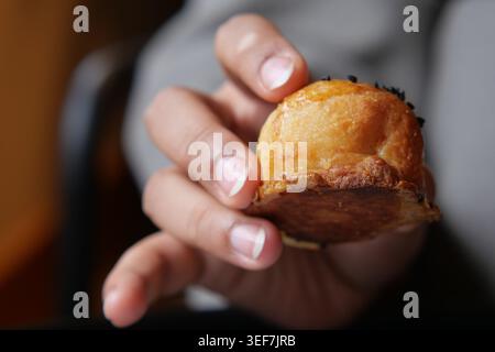 Person holds a baked pastry in hands while preparing to eat Stock Photo ...