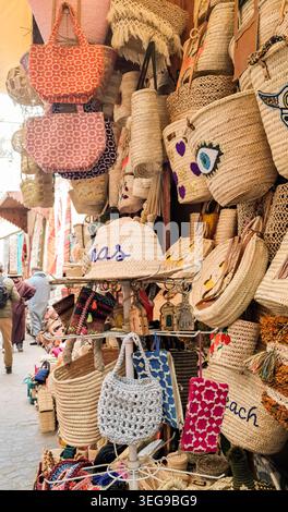 Traditional wicker hats, bags, and baskets hang outside a rustic ...