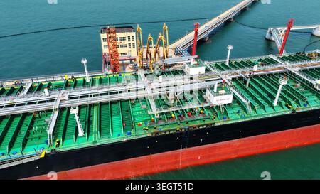 An oil tanker unloads imported crude oil at Qingdao Port in east China ...