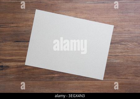 A blank piece of white paper sits on a brown background with dots. It ...