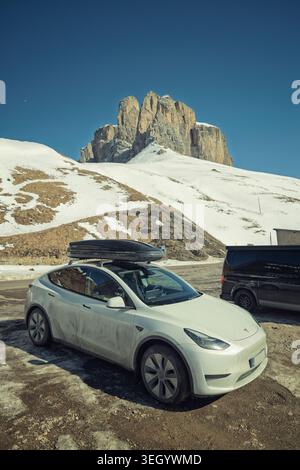 Modern car with black roof box covered in active white soap foam during ...