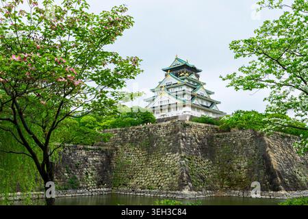 Osaka Castle surrounded by stone walls and a peaceful moat. The castle ...