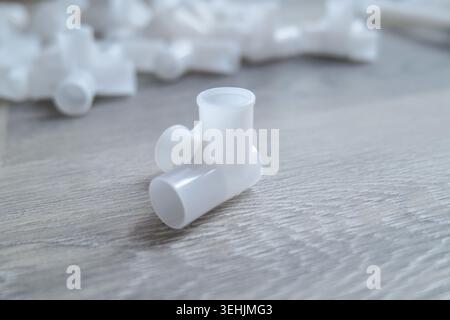 White Plastic Pipe Connectors Scattered on Wooden Floor for DIY ...