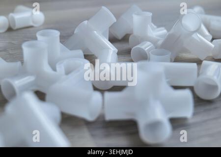 White Plastic Pipe Connectors Scattered on Wooden Floor for DIY ...