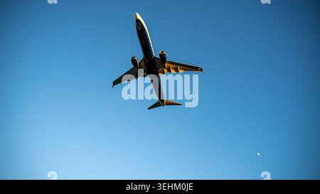 A passenger aircraft is visible in the cloudless sky before landing at ...