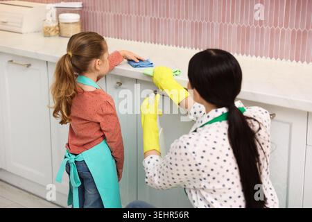 Spring cleaning. Mother and daughter wiping surfaces with rags and ...
