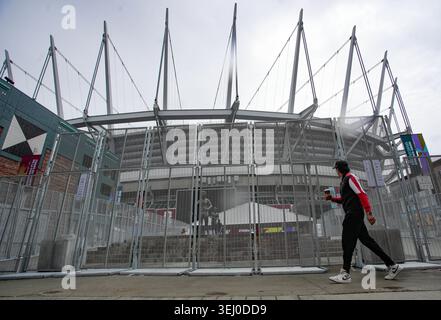 A man walks past fencing surrounding BC Place for the FIFA World Cup ...