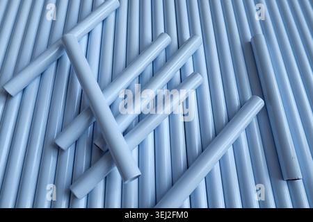 Hand holding white plastic pipes against a background of more pipes ...