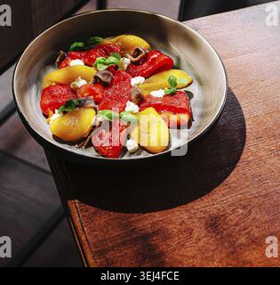 Vibrant red roasted peppers in white ceramic dish, glossy texture ...