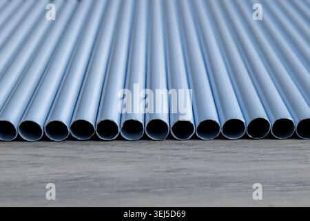 Row of light blue PVC pipes on concrete surface Stock Photo - Alamy