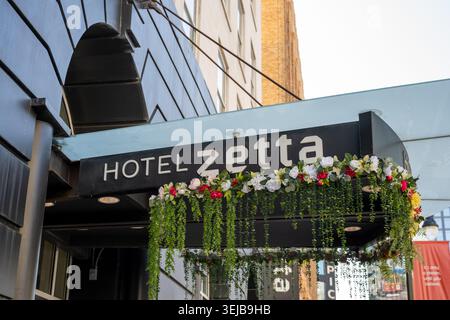 Entrance canopy of Hotel Zetta with floral decorations and building ...