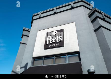 Peets Coffee logo on exterior of gray building against clear blue sky ...