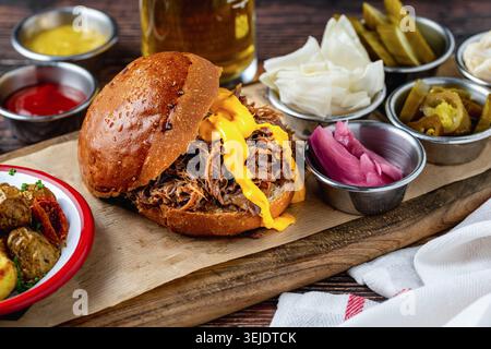Slow cooked pulled rib beef burger with melted cheese and sides Stock ...