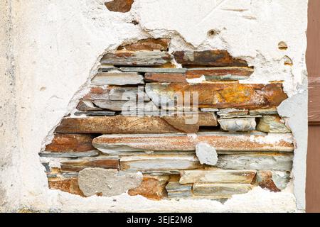Wall peeling and exposing stone bricks in Spain Stock Photo - Alamy
