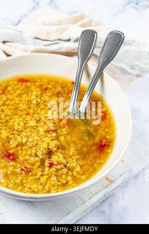 Homemade creamy lentil soup served with crispy croutons in a white bowl ...