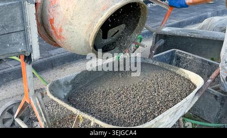 Heavy-duty concrete pouring bucket hanging in mid-air over scaffolding ...