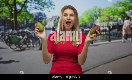 Two hands display a ripe red tomato and a bright yellow bell pepper ...