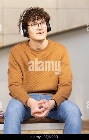 Teenage student wearing headphones using laptop with copy space Stock ...
